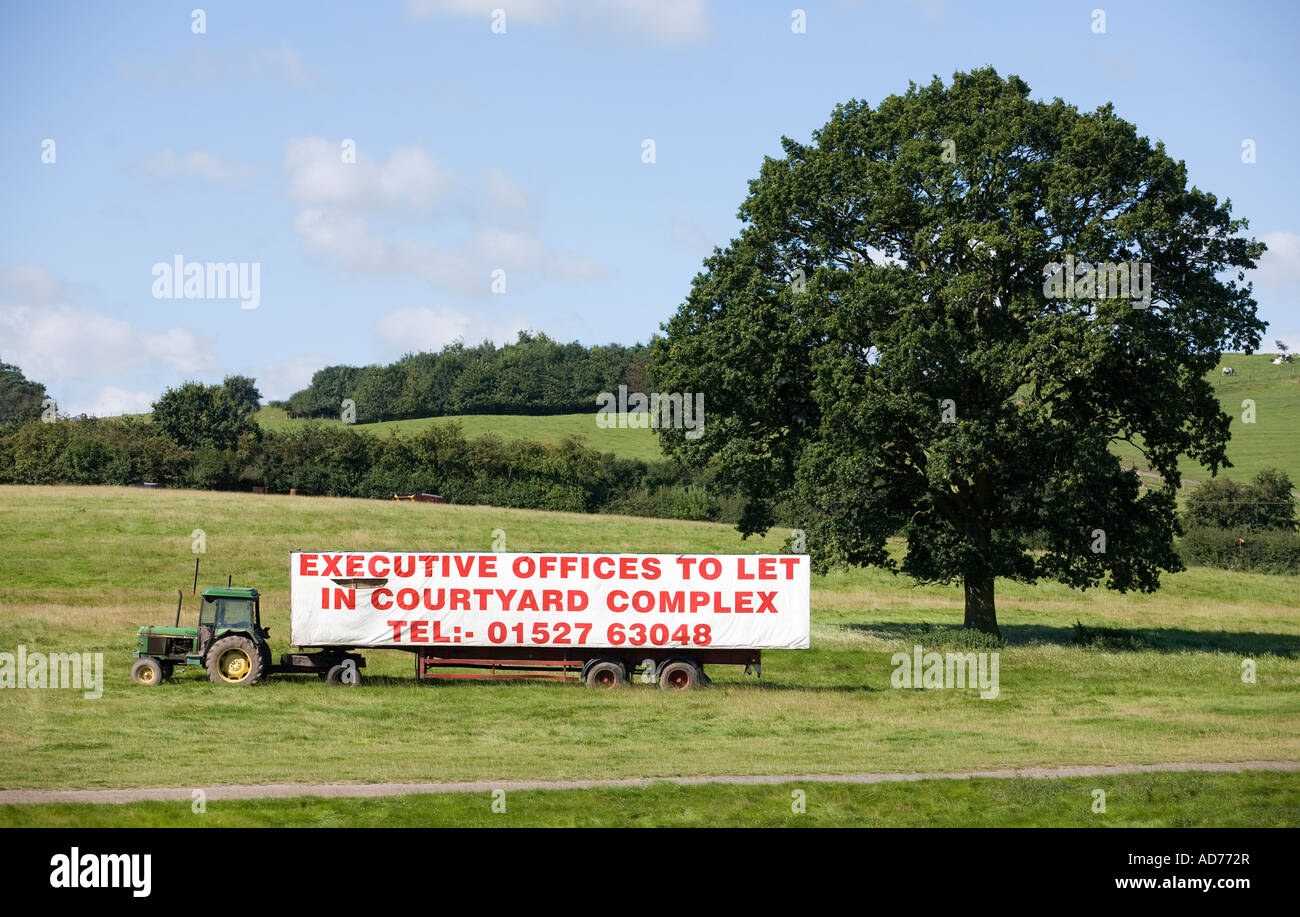 A giant mobile advertising banner parked in a field on farming land in ...