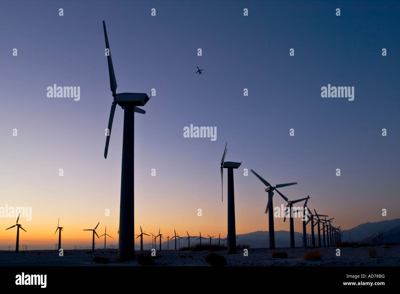 Jet flying over Array of Clean Energy Power windmill turbines at wind ...