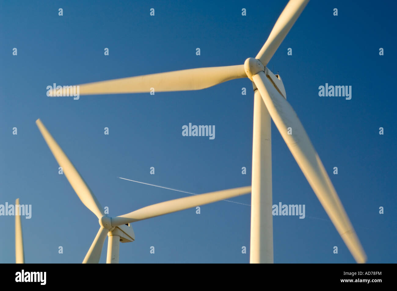 Jet plane contrail flying over Clean Energy Power generating windmills ...