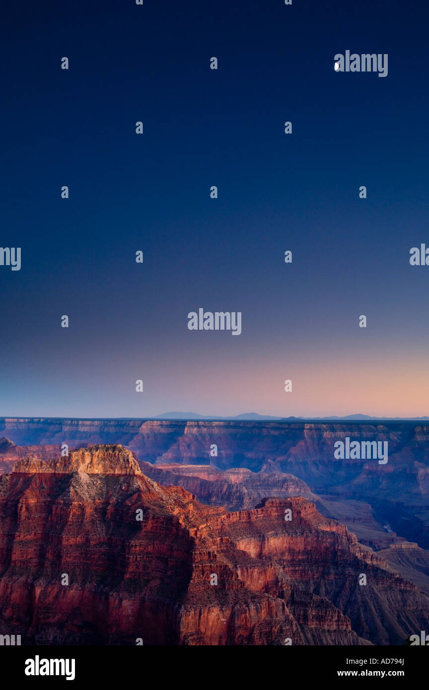 Evening light and moon over red rock cliffs along the North Rim at ...