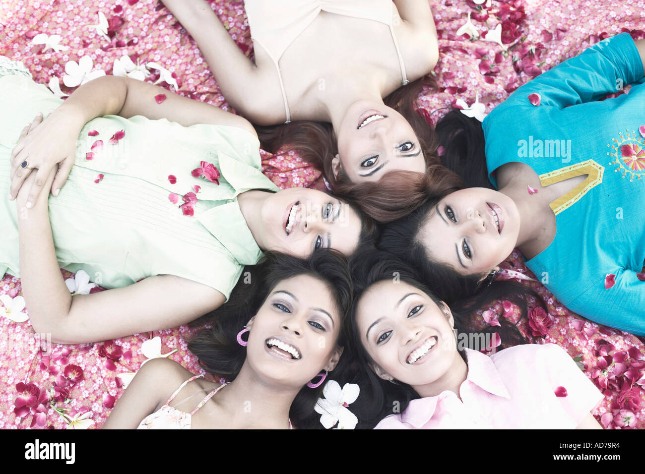 Portrait of a teenage girl and four young women lying on their back ...