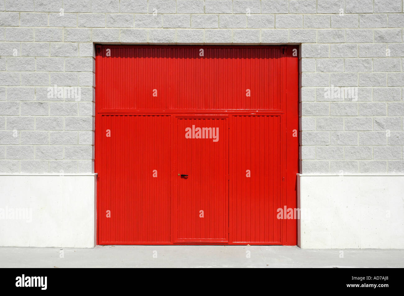 Large red door in white house wall Stock Photo - Alamy