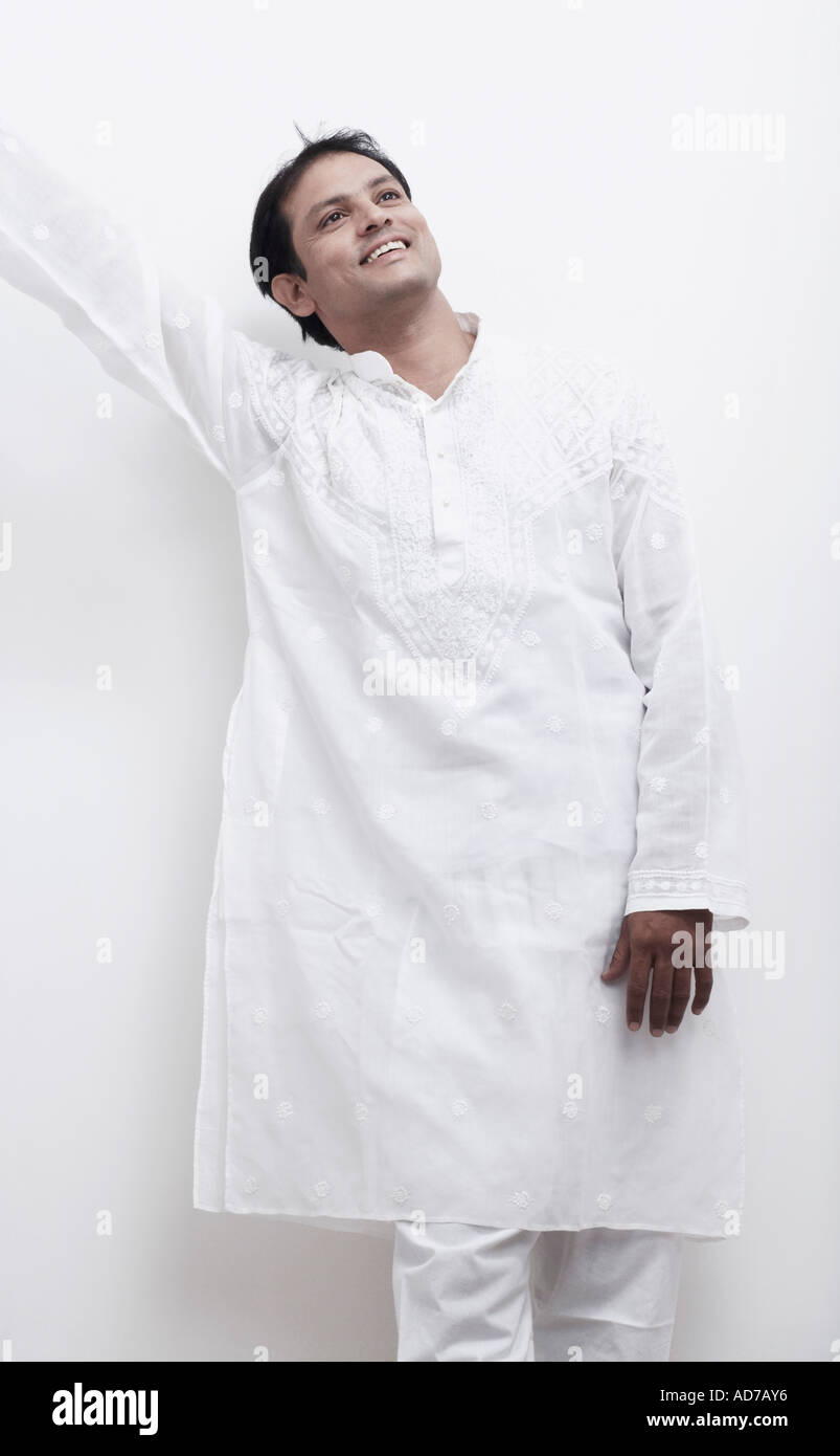 Mid adult man standing with his hand raised Stock Photo - Alamy