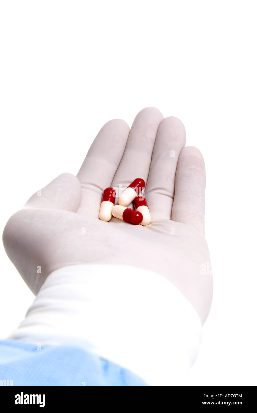Doctor gloved hand holding medicine Stock Photo - Alamy