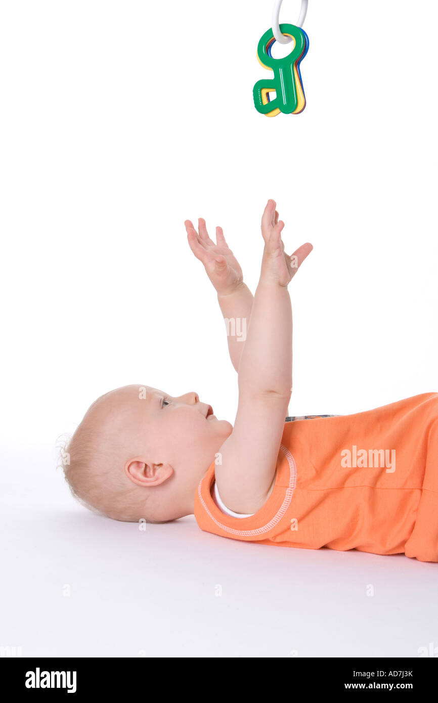 Little boy reaching for a toy Stock Photo - Alamy