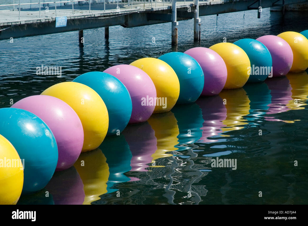 Large multi coloured floating balls forming a barrier around a play ...