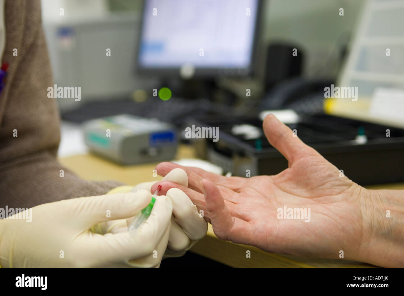 Nurse performing a finger prick blood test on a patient Stock Photo - Alamy