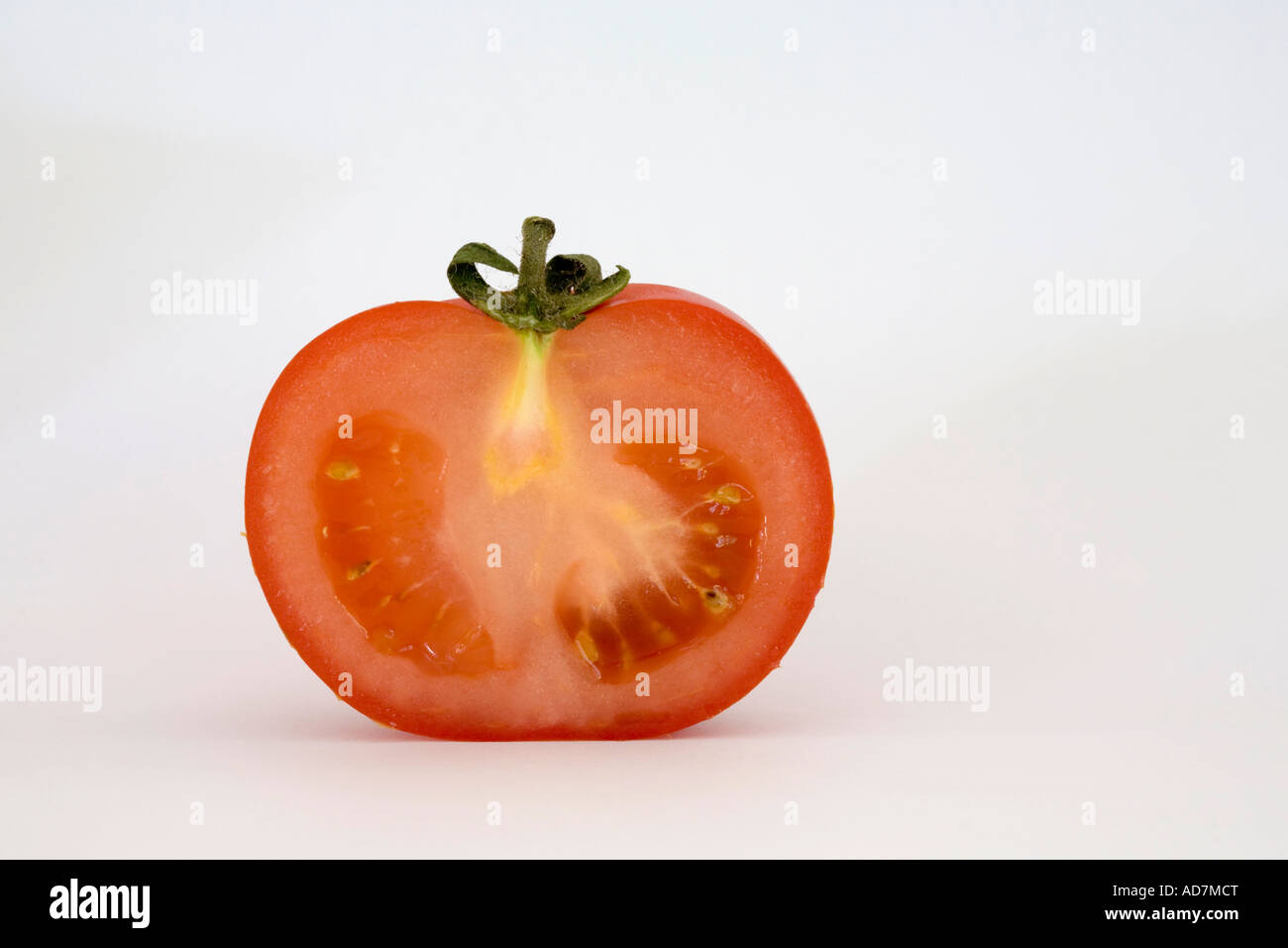 Single tomato half on a white background Stock Photo - Alamy