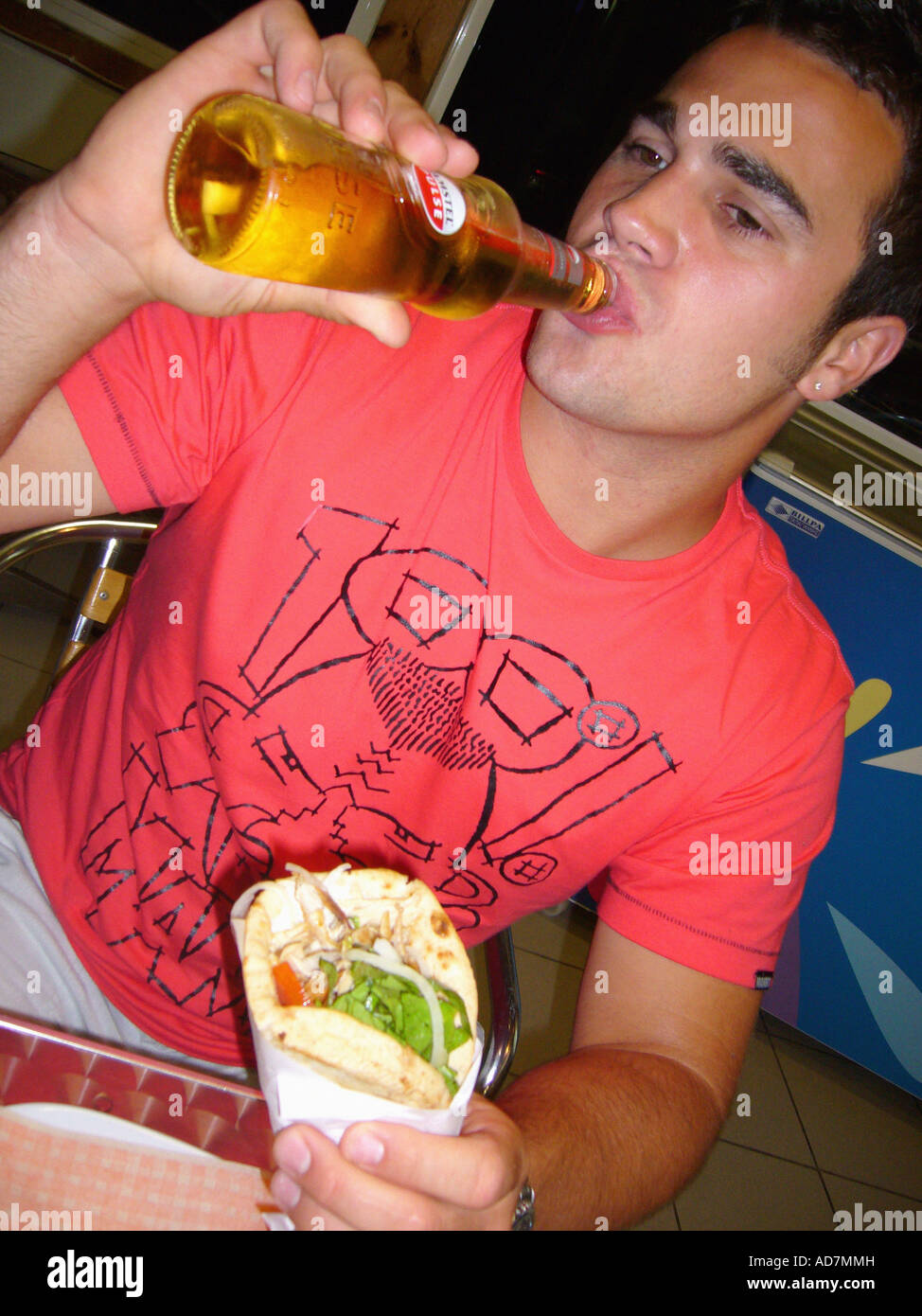 young man looking drunk eating a kebab and drinking more beer Stock ...