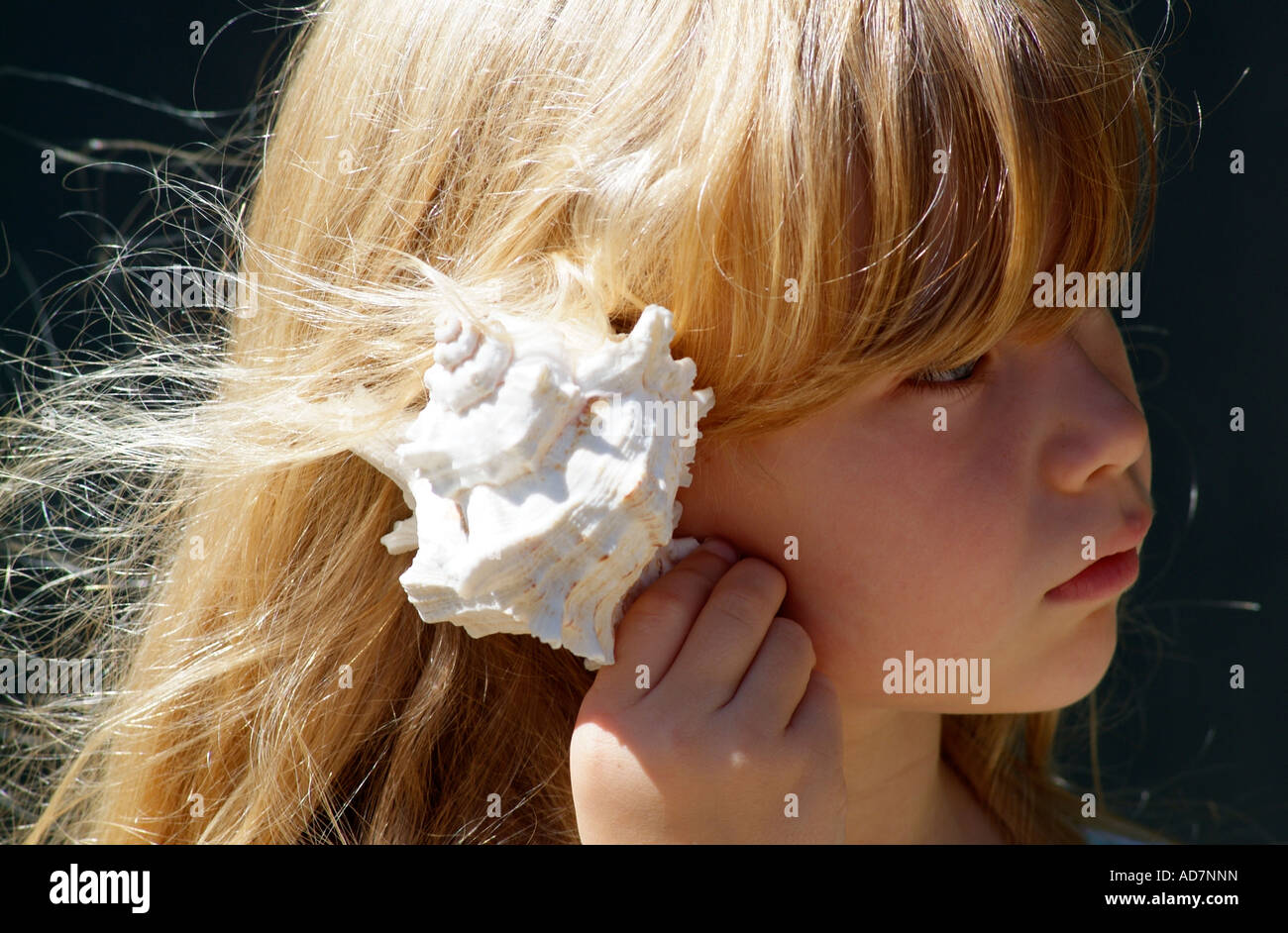 Little girl with seashell hi-res stock photography and images - Alamy