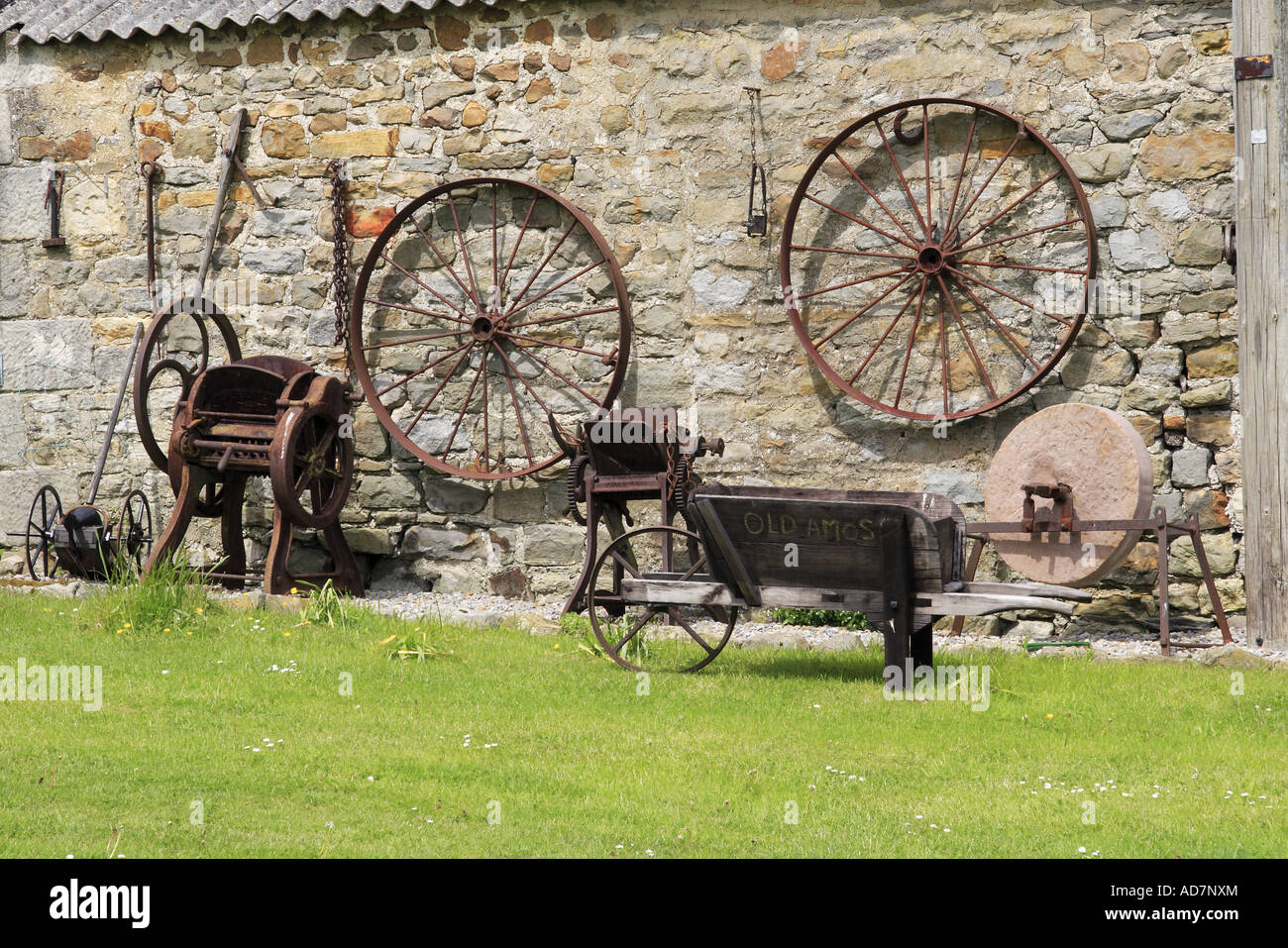 Old farm implements wagon wheels decorate a stone barn in Thornton ...