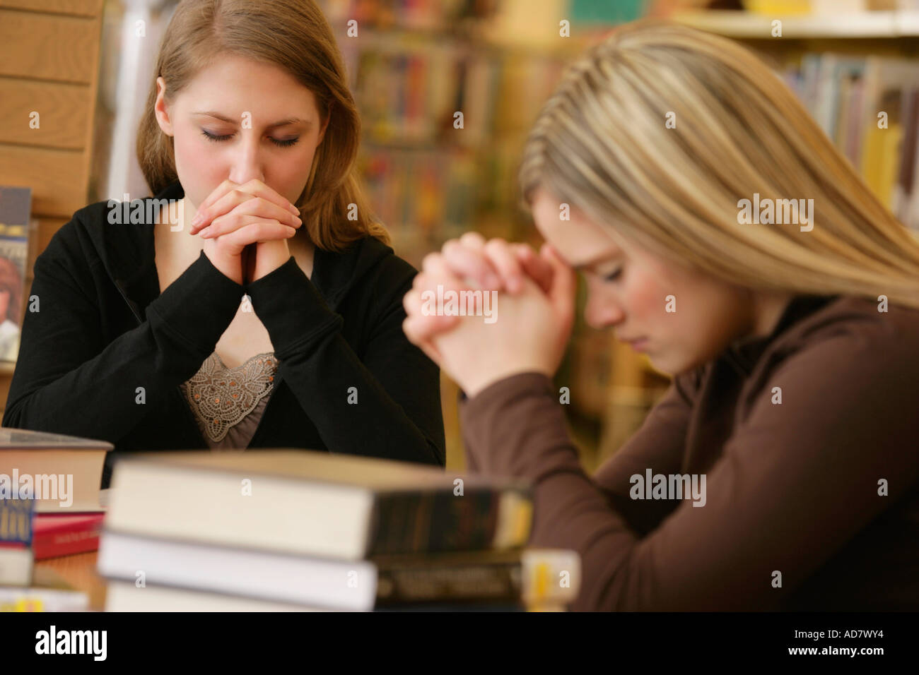 Two women praying in library Stock Photo - Alamy