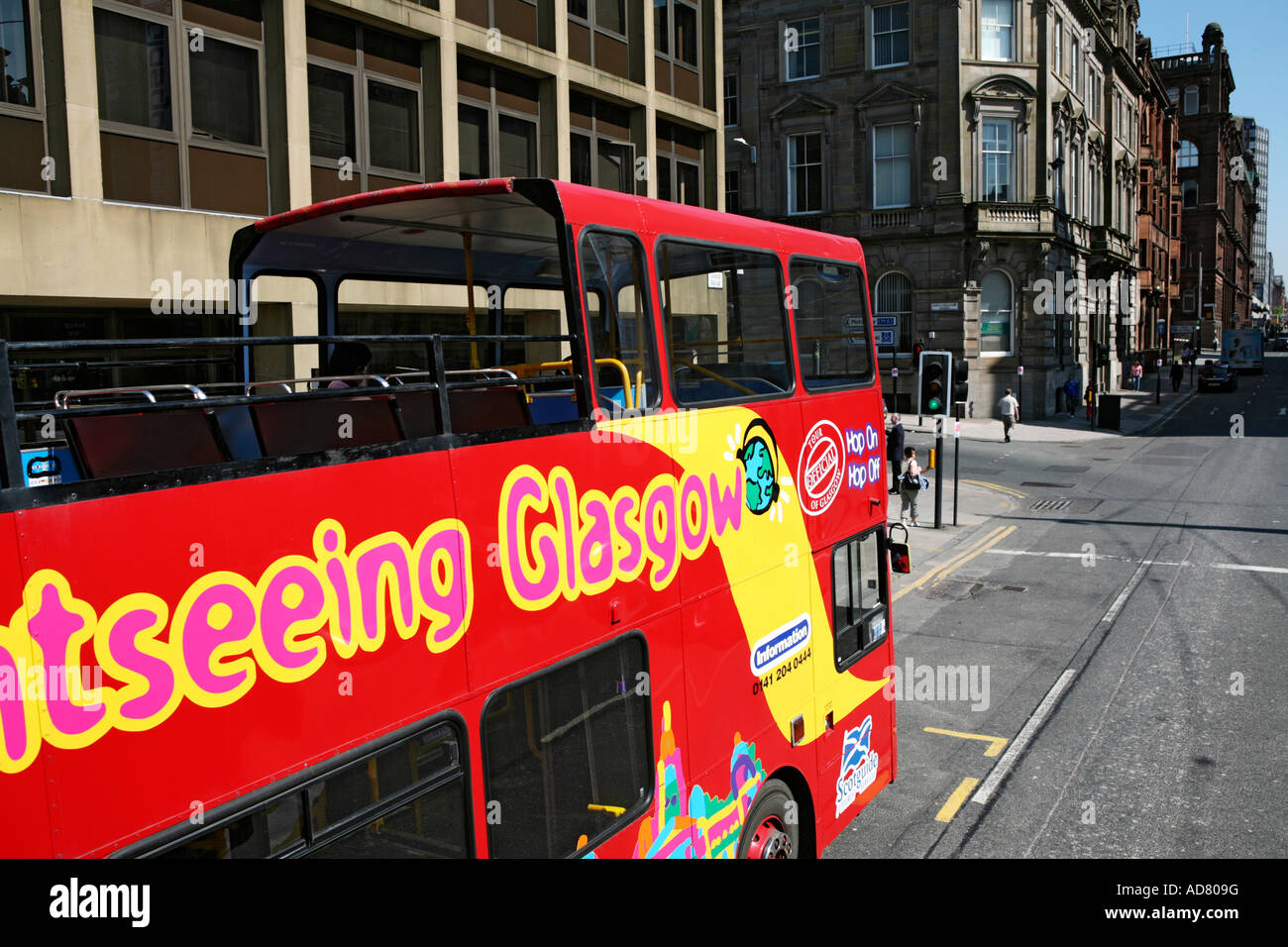 A bright red sightseeing tour bus on George St, Glasgow on a bright ...