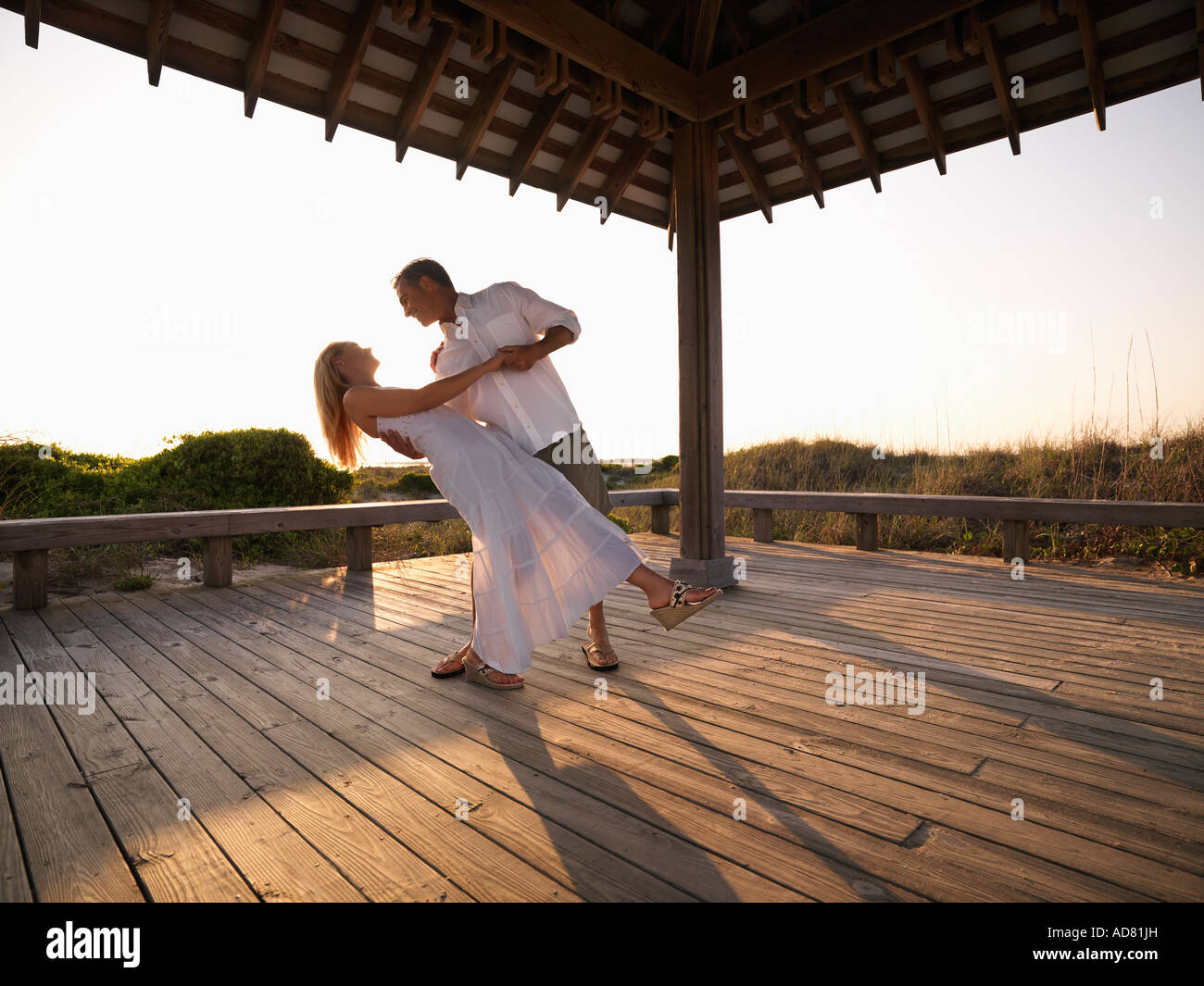 Caucasian couple dancing under gazebo at the beach Stock Photo - Alamy
