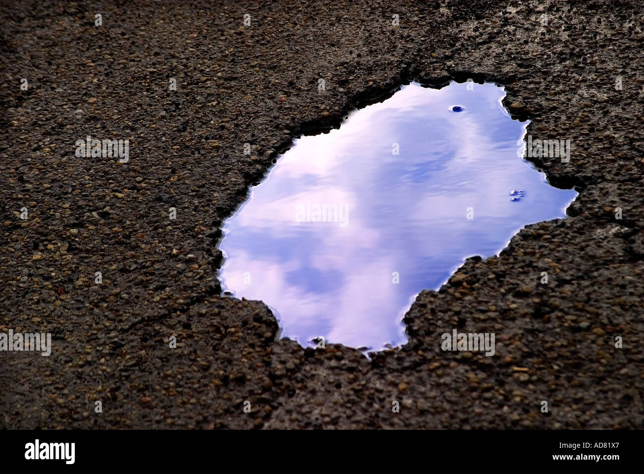 Clouds reflecting in puddle Stock Photo - Alamy