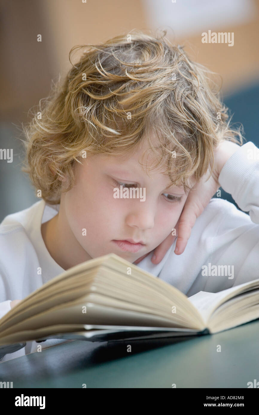 Boy reading book Stock Photo - Alamy