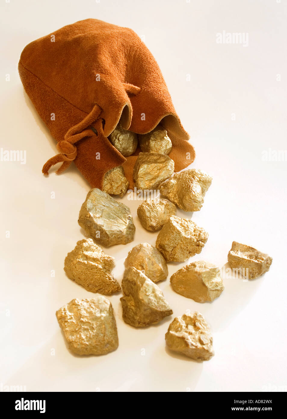 Gold nuggets spilling out of a leather pouch Stock Photo - Alamy