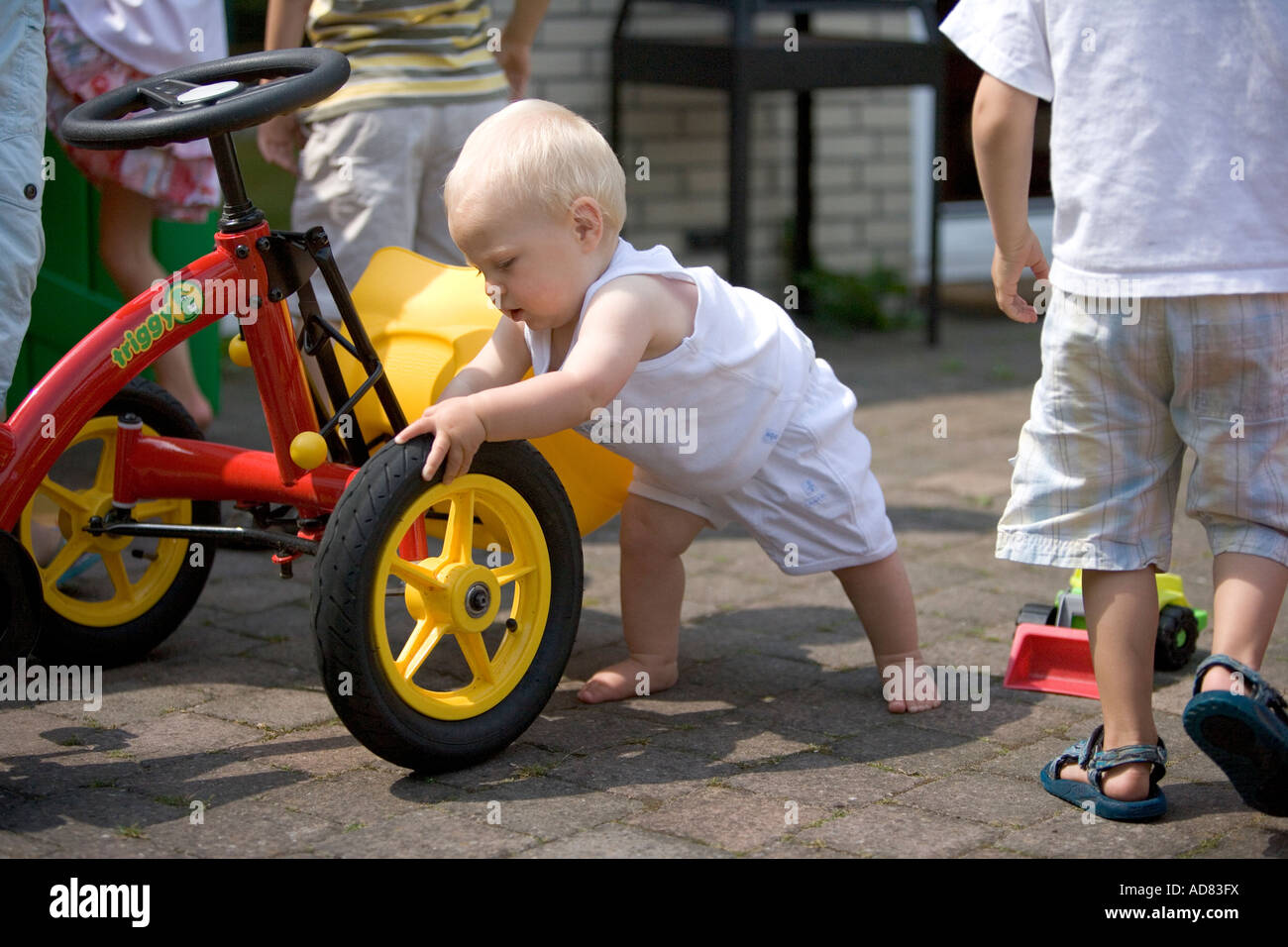 Baby boy discovers a wheel Stock Photo - Alamy