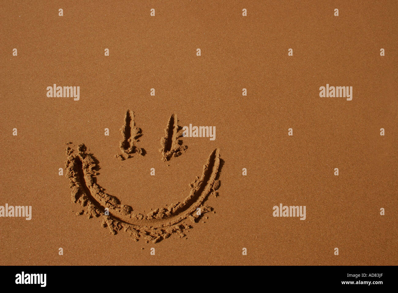 Happy face in the sand Stock Photo - Alamy