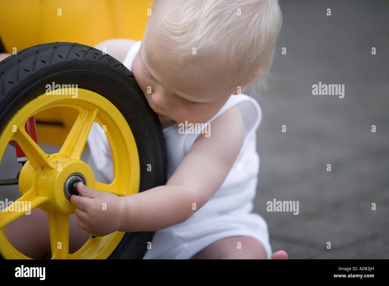 Baby boy discovers a wheel Stock Photo - Alamy