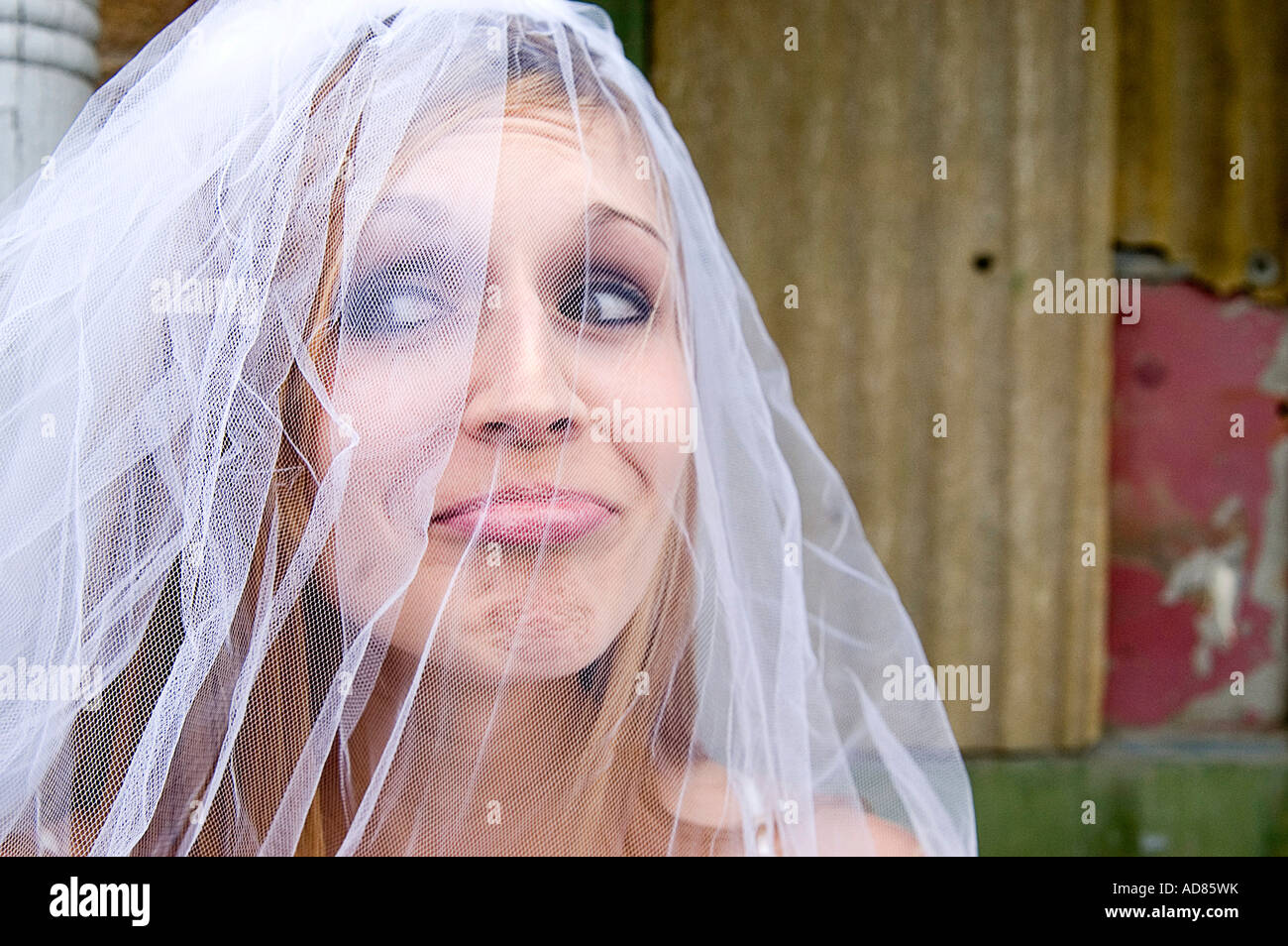 close up shot of a bride as she makes a funny face because her veil is ...