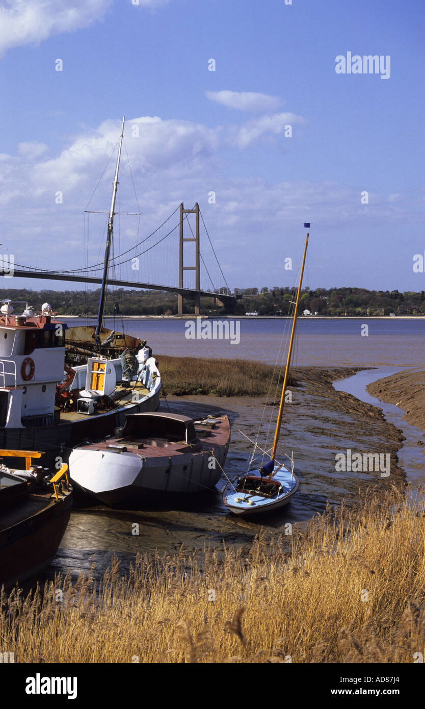 boats moored by the humber estuary with the humber bridge behind ...