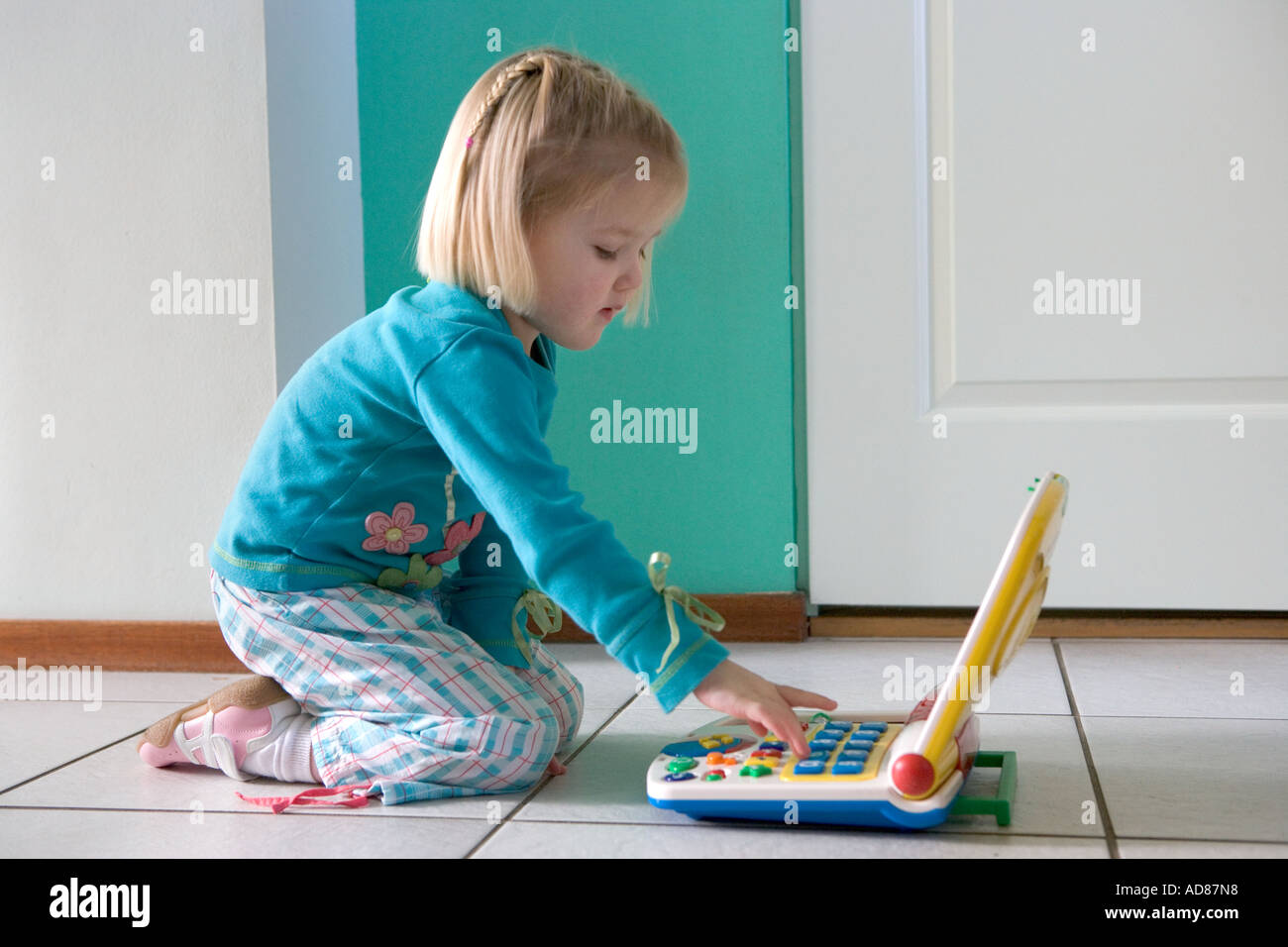 Four year old girl is playing with a toy computer Stock Photo - Alamy