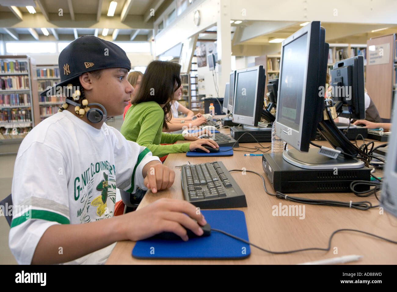 Teenages behind a computer in the library Stock Photo - Alamy