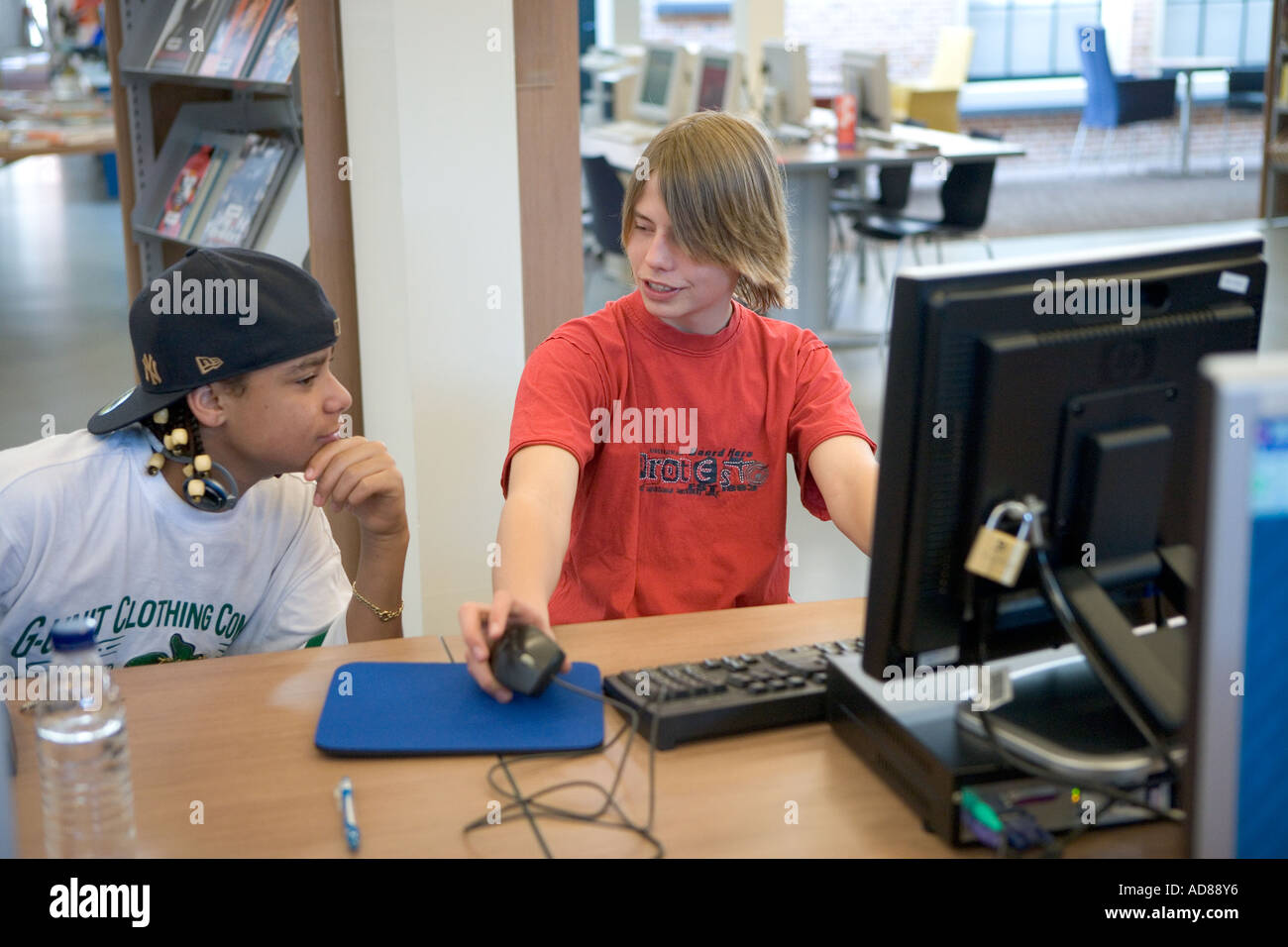 Two teenage boys behind a computer in the library Stock Photo - Alamy
