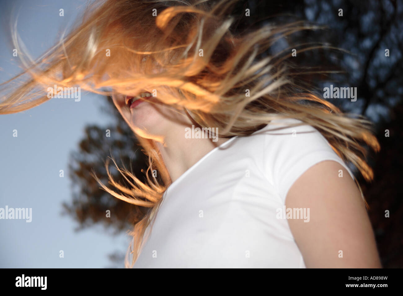 Young woman tossing her long blond hair outdoors, view from below Stock ...