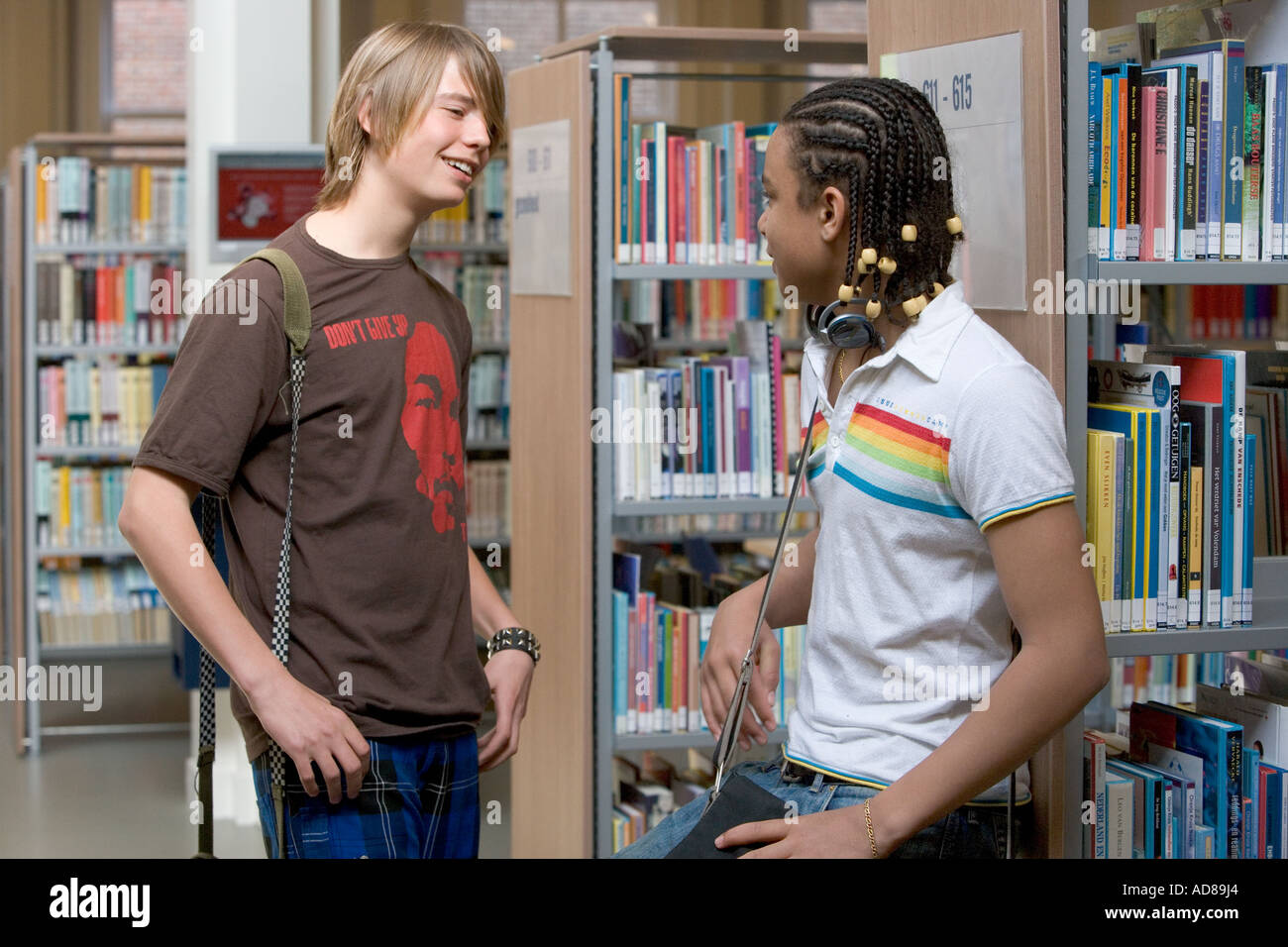 Two teenage boys talking in the library Stock Photo - Alamy