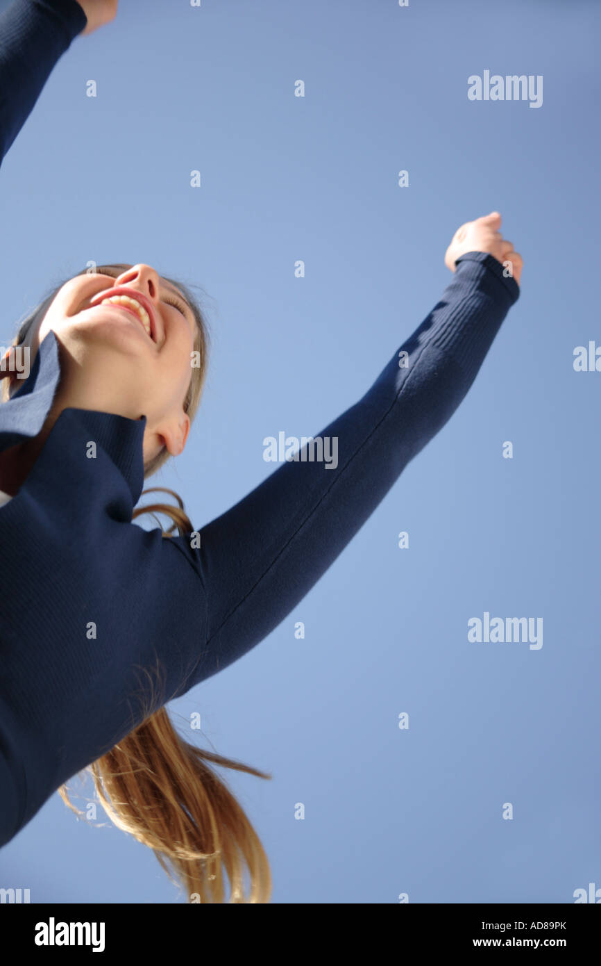 Young woman jumping happily in front of blue sky, view from below Stock ...
