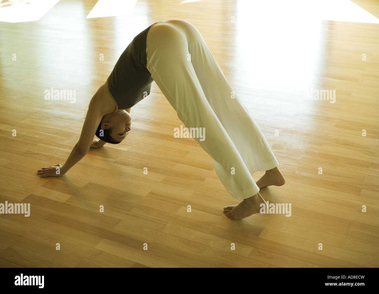 Woman doing downward dog pose Stock Photo - Alamy