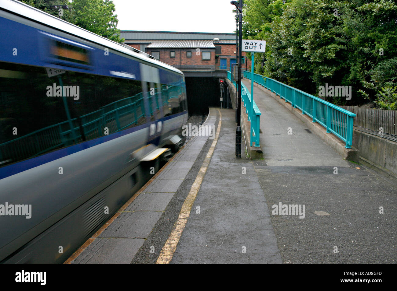 A commuter train passes through a station at speed The way out is to ...