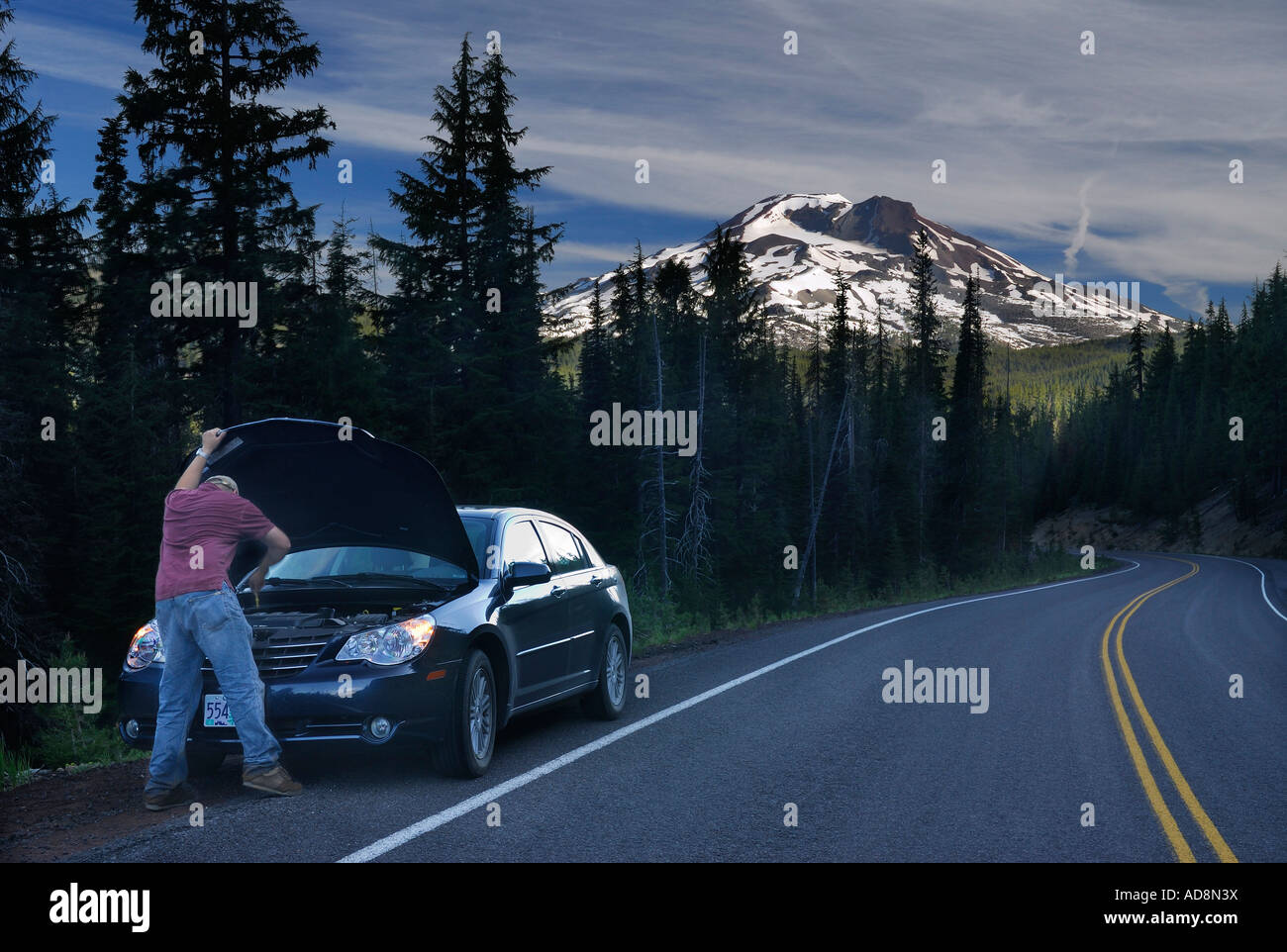 Owner checking engine of stalled car on shoulder of curving Cascade ...