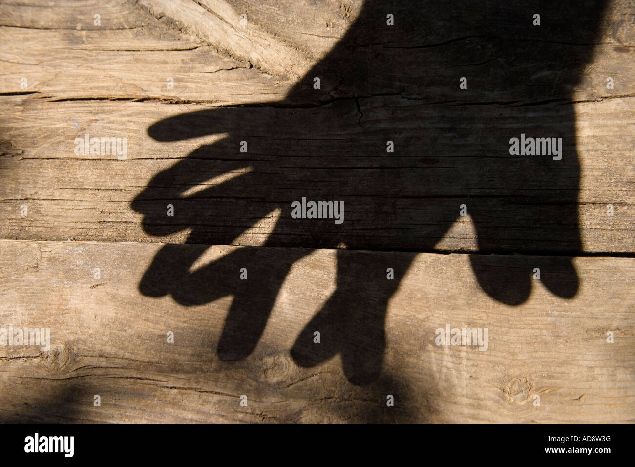 Male hands casting shadow over wooden table Stock Photo - Alamy