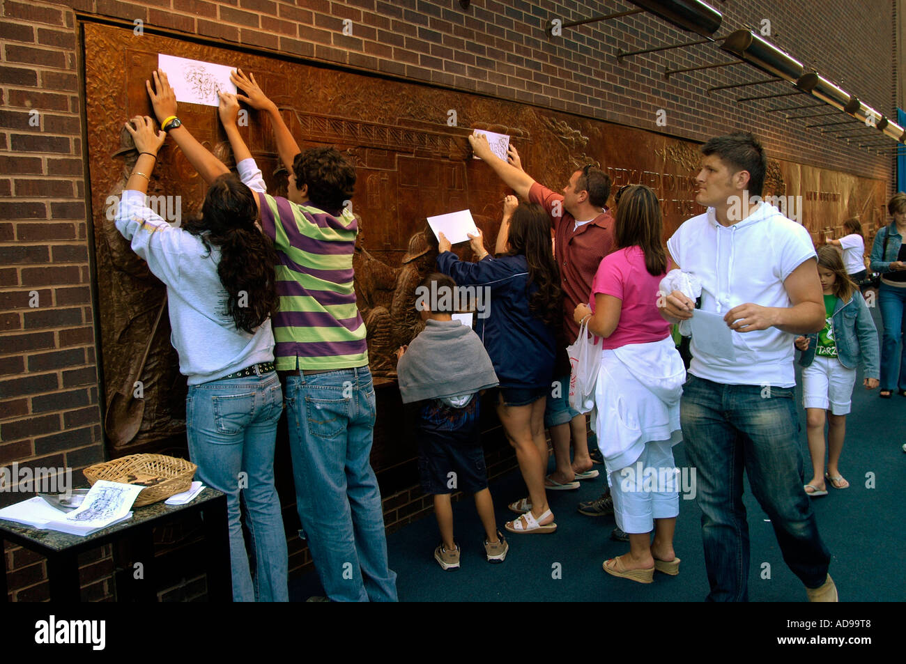 Visitors to Ground Zero make graphite rubbings of the bas relief ...