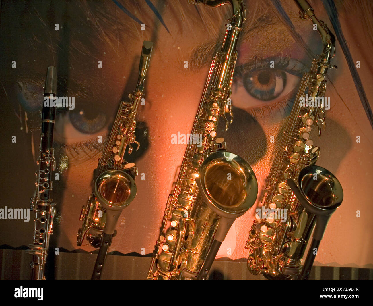 four saxophones at a wall with a picture of a look of a woman eye Stock ...