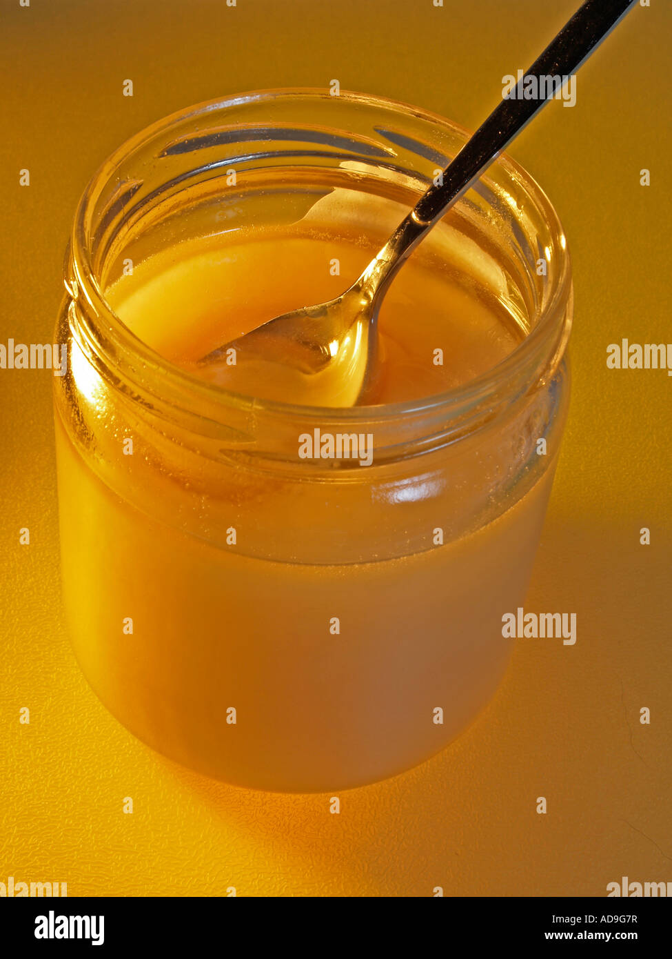 spoon in glass filled with honey Stock Photo - Alamy