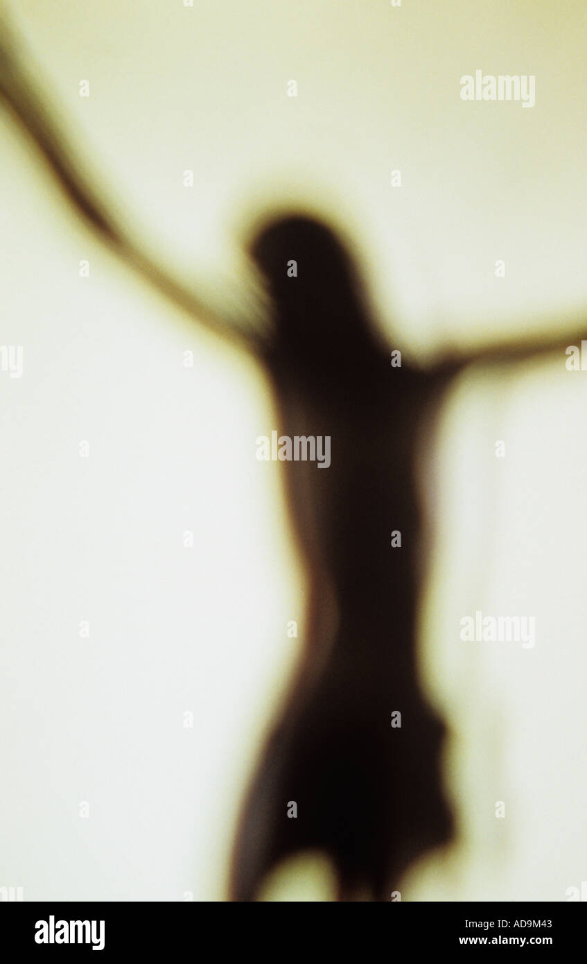 Impressionistic shadowy figure with arms raised and splayed and ...