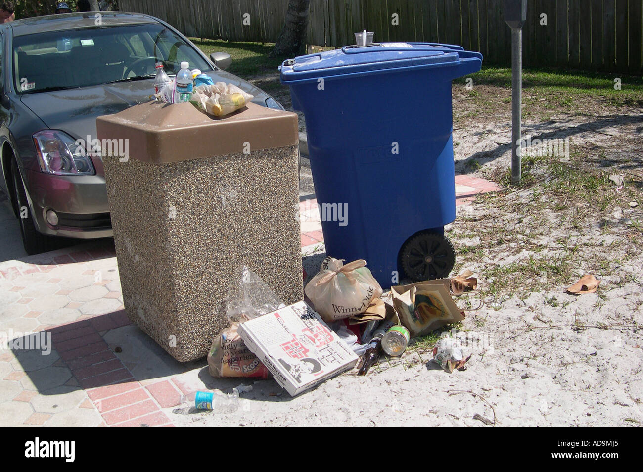 Garbage on ground around garbage cans Stock Photo - Alamy