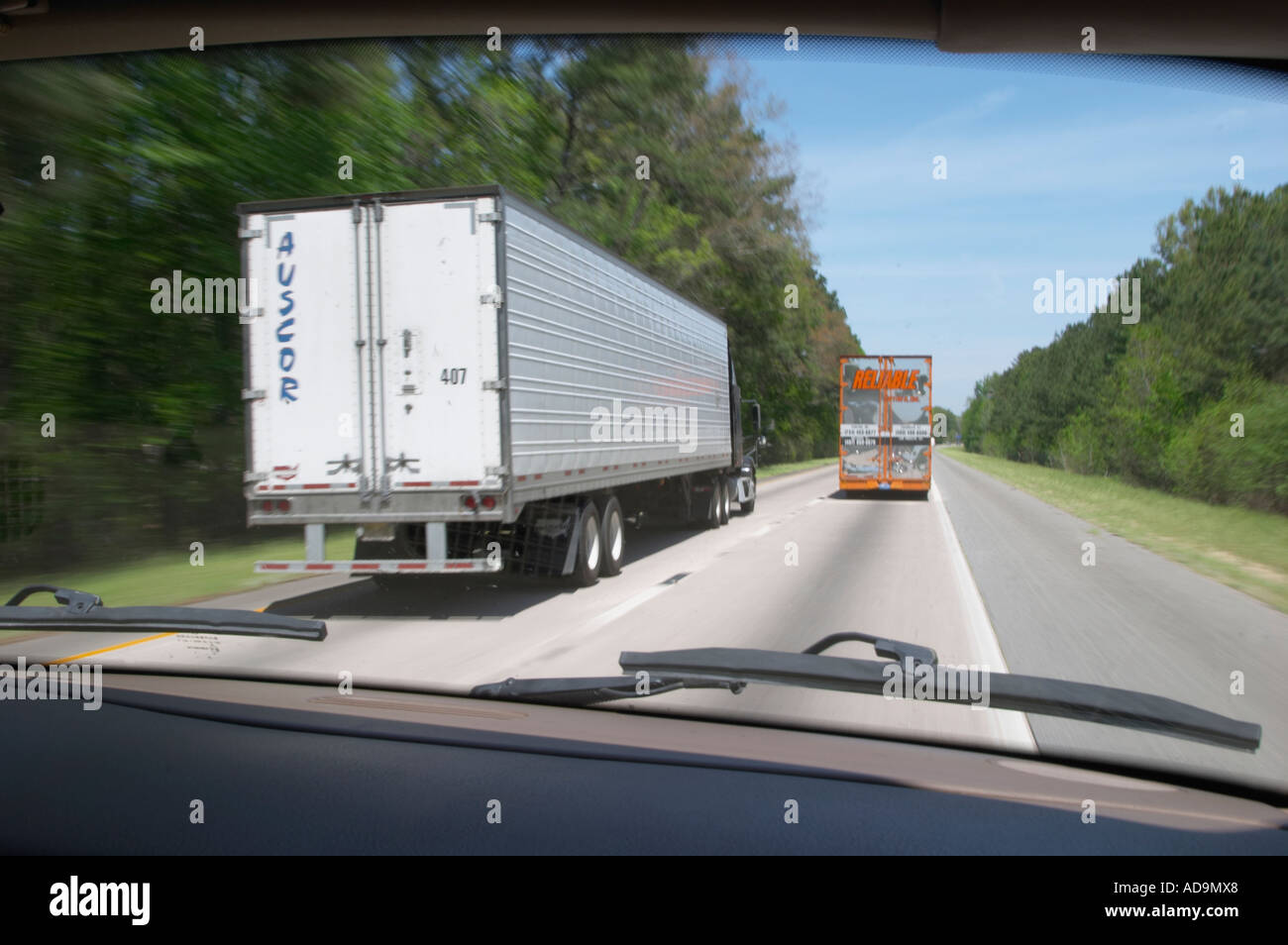 Passing truck on interstate highway seen though windshield of car Stock ...