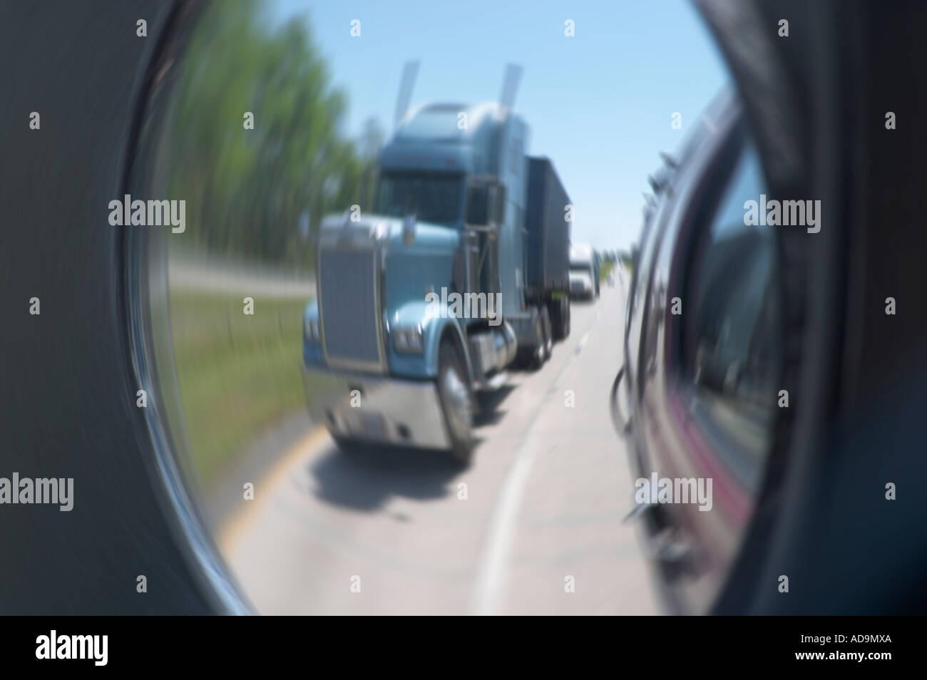Passing truck on interstate highway seen in rearview mirror Stock Photo ...