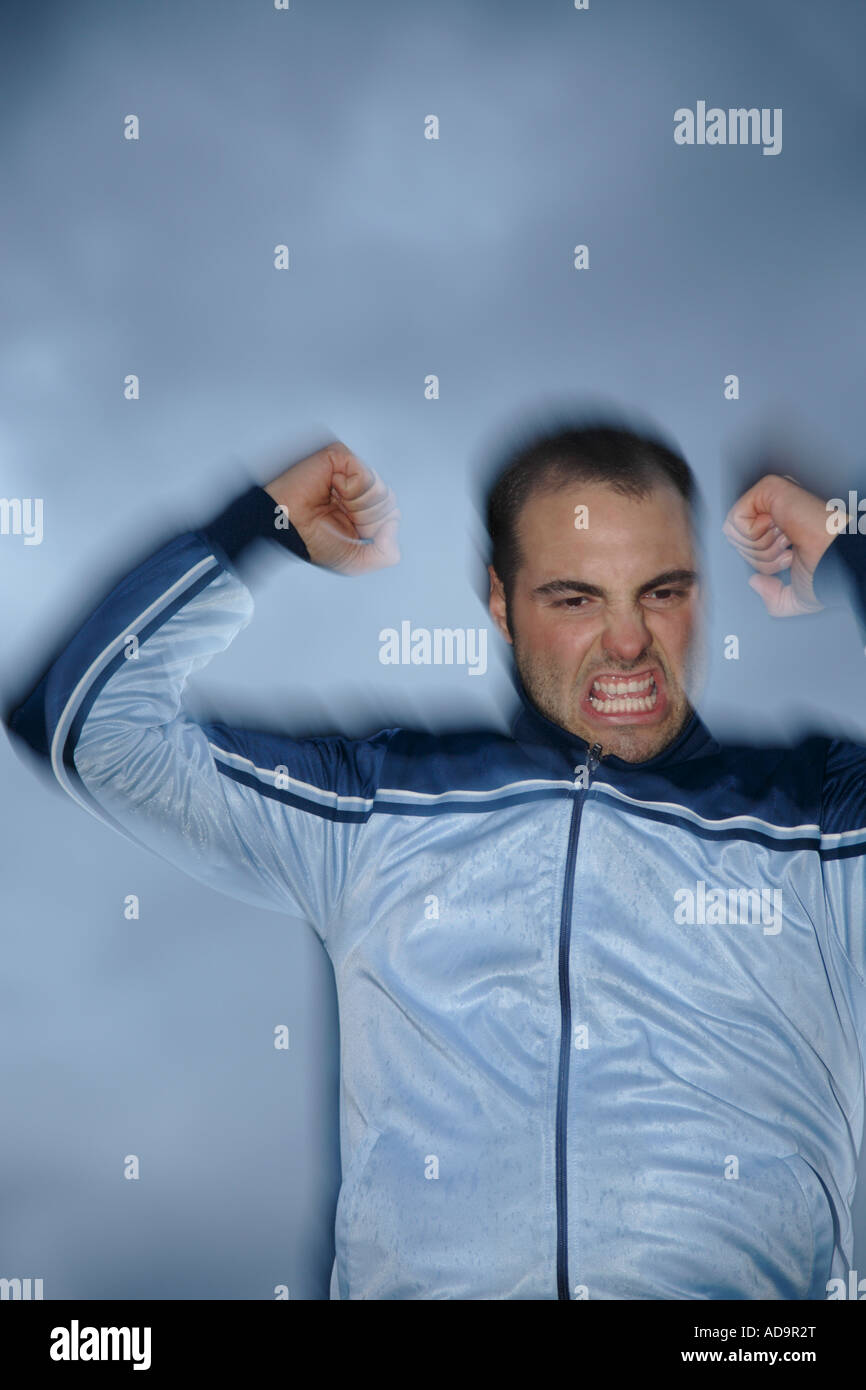 Young man in a sweat suit jacket cheering in front of dark clouds Stock ...