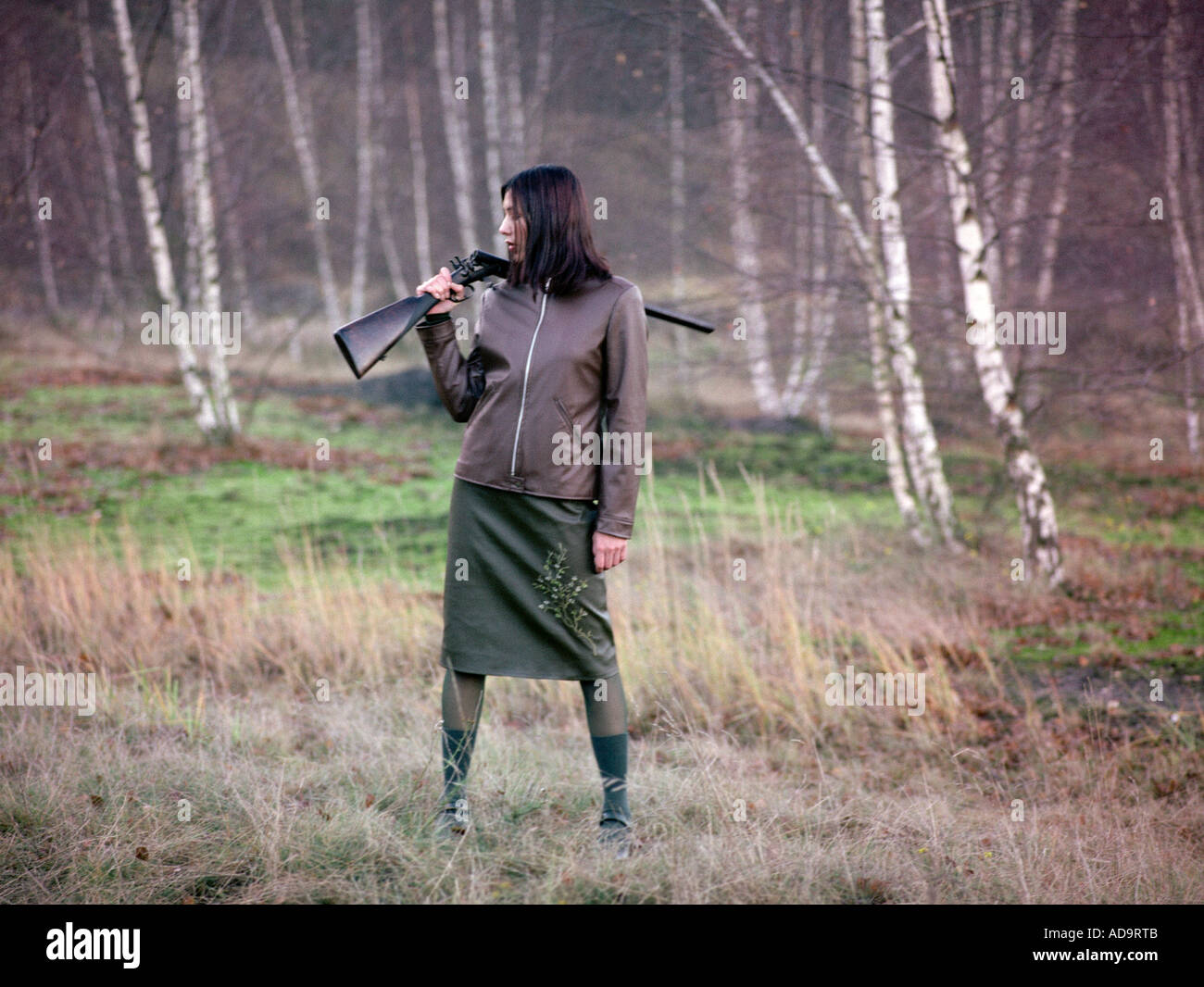Girl in forest with gun Stock Photo - Alamy