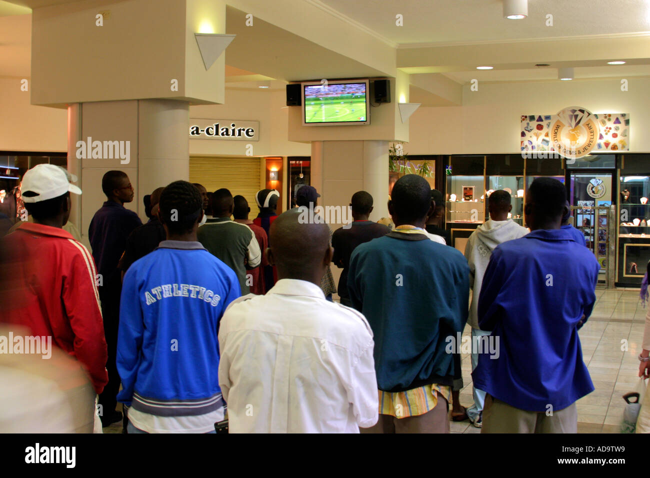 People watching World Cup 2006 football match on a tv in shopping mall ...