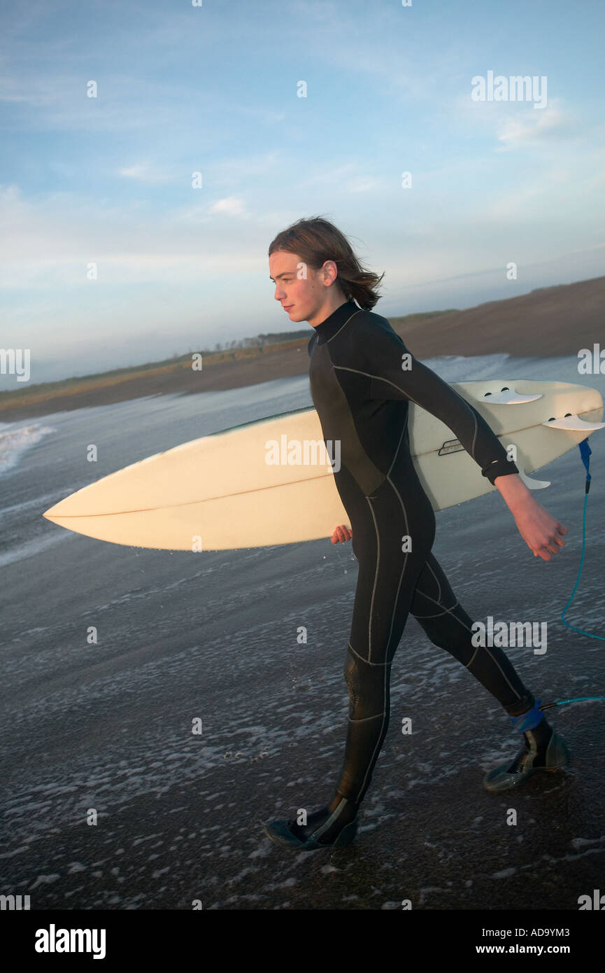 Young surfer walking with determination toward the sea Stock Photo - Alamy