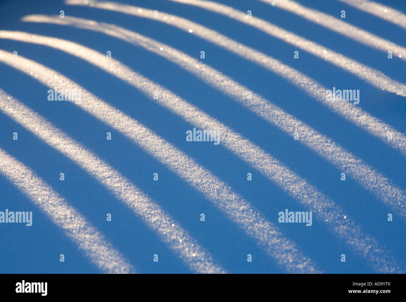 Lines of light and shadows form a repeating line pattern to snow ...