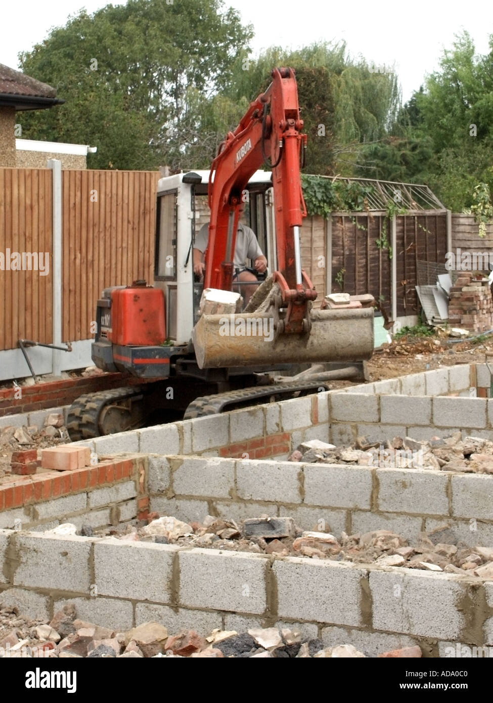 New house under construction mini digger placing hardcore rubble on ...