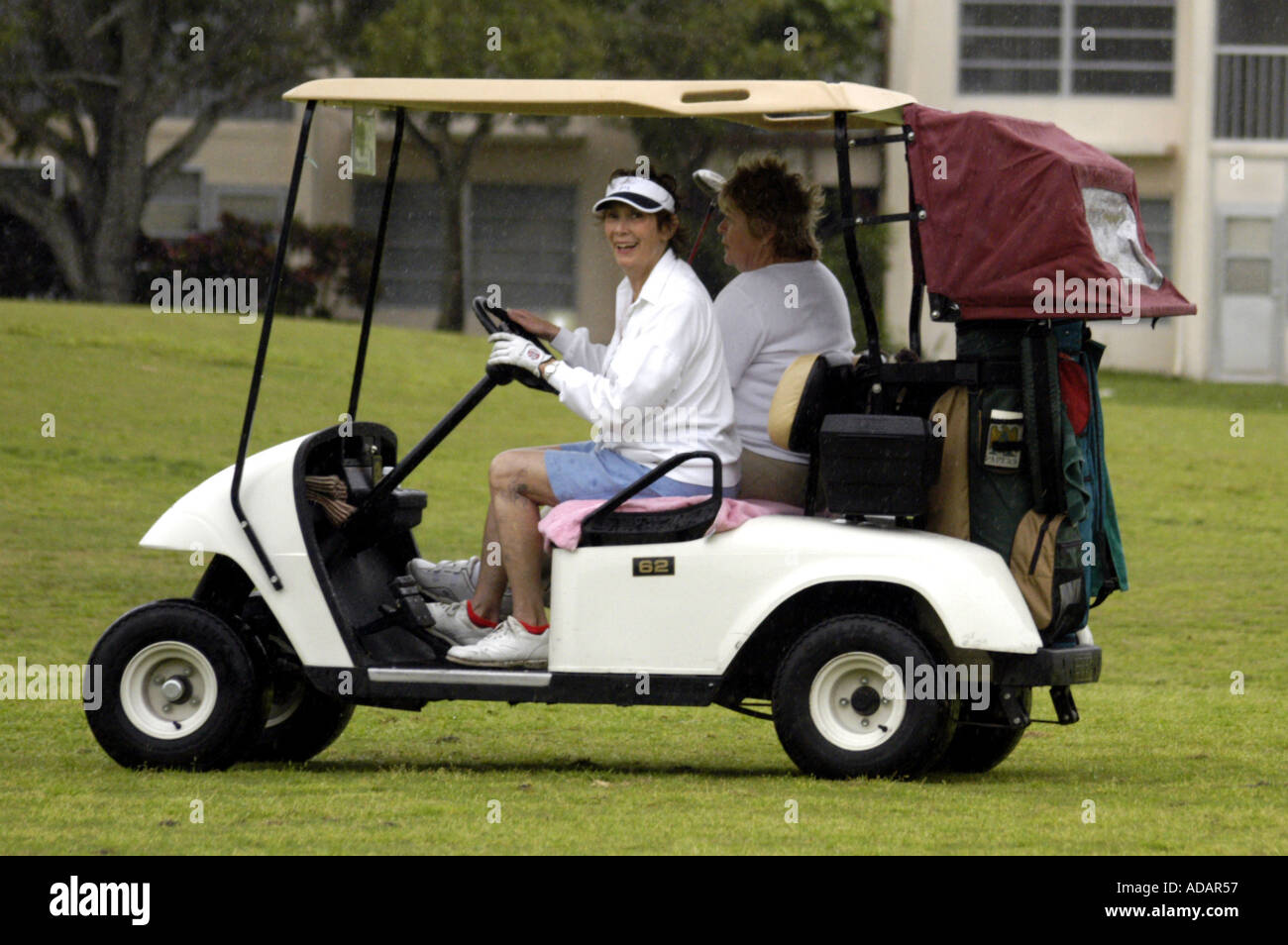 Senior woman driving golf cart on golf course Stock Photo - Alamy